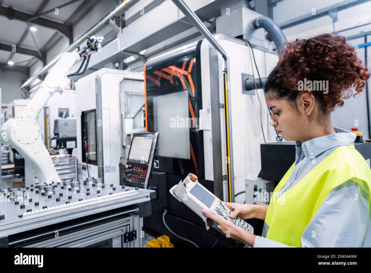 Engineer operating robotic arm with equipment in industry Stock Photo ...