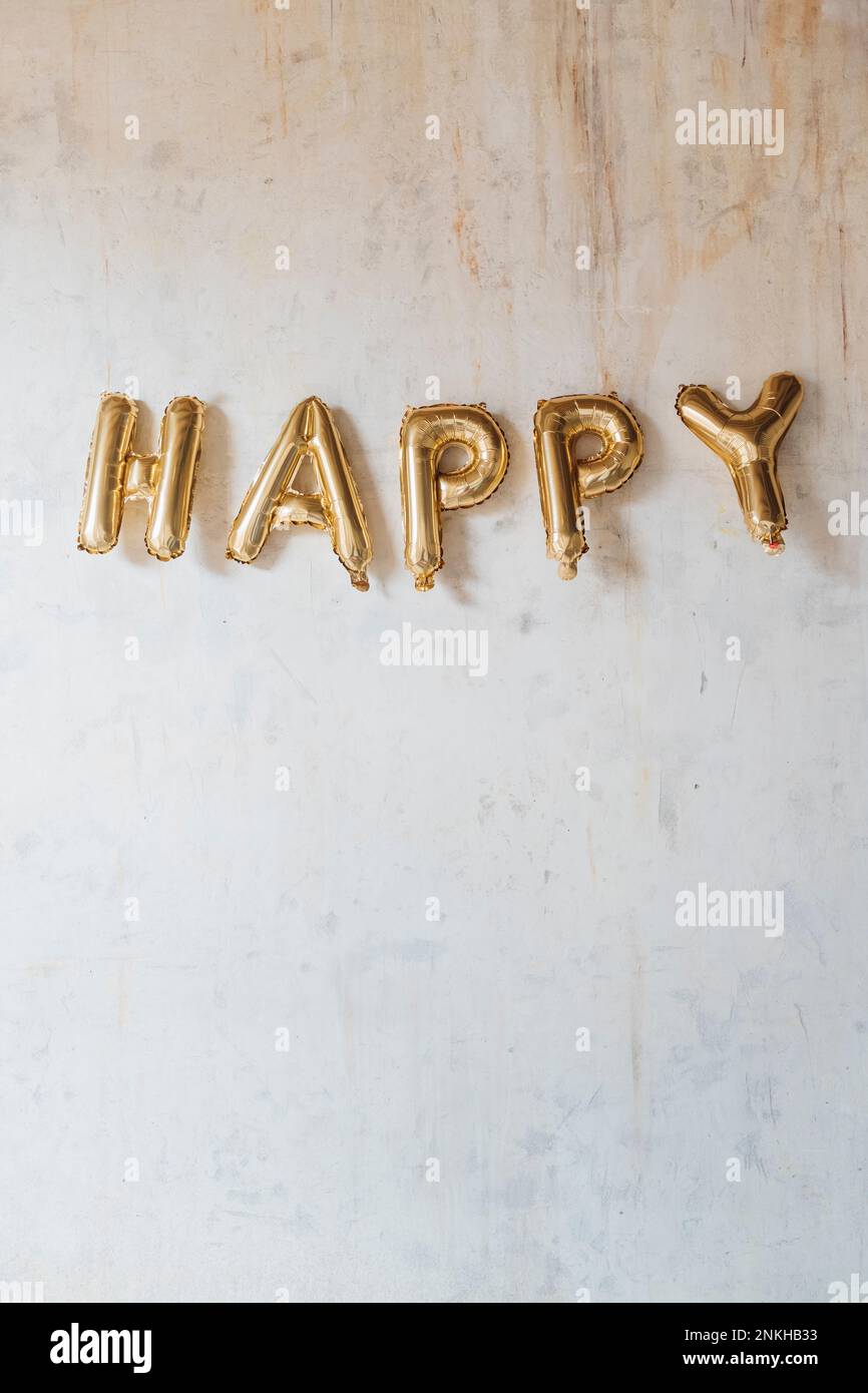 Happy text made with inflated balloons hanging on wall Stock Photo - Alamy