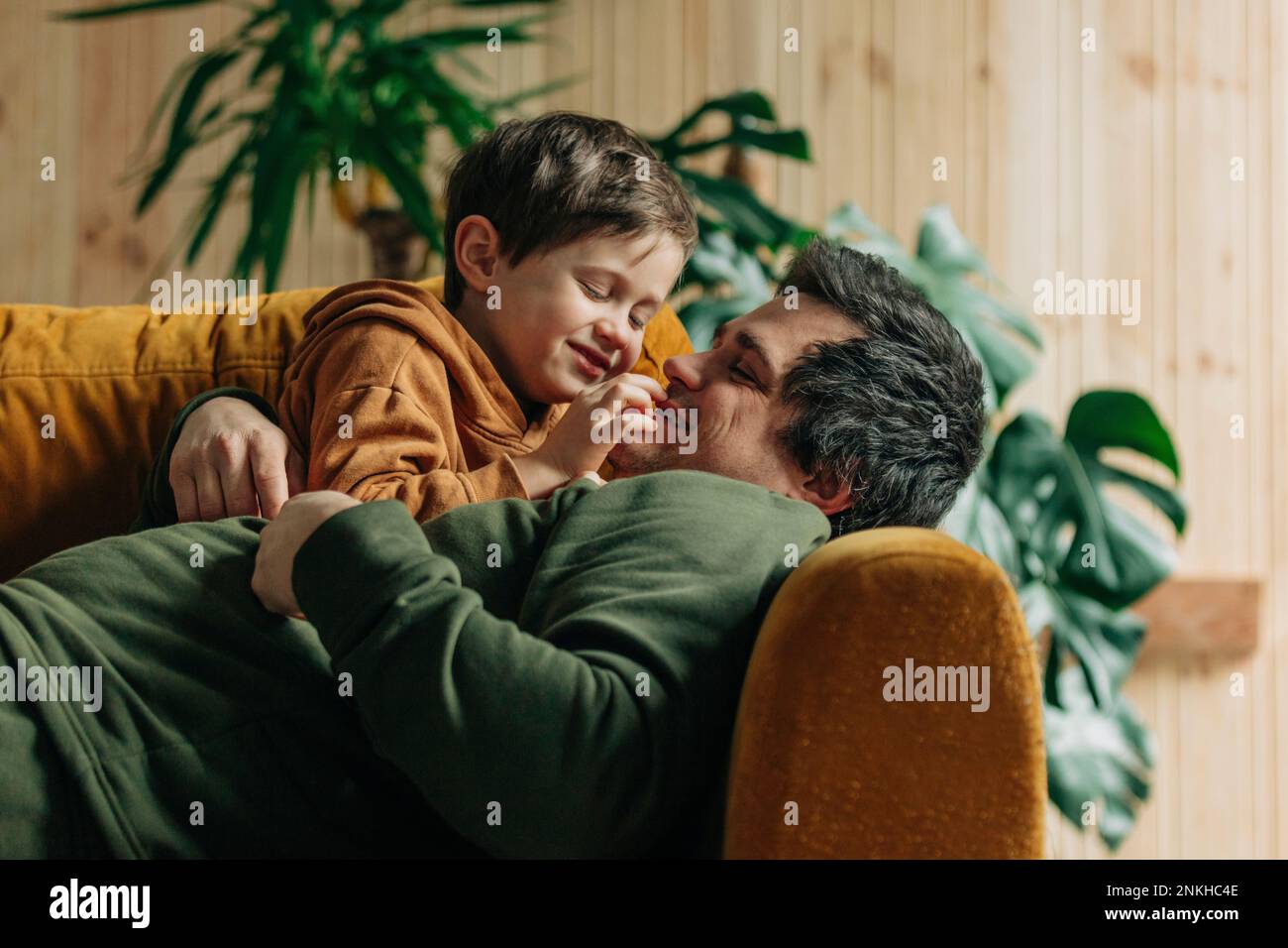 Playful father having fun with son on sofa at home Stock Photo - Alamy