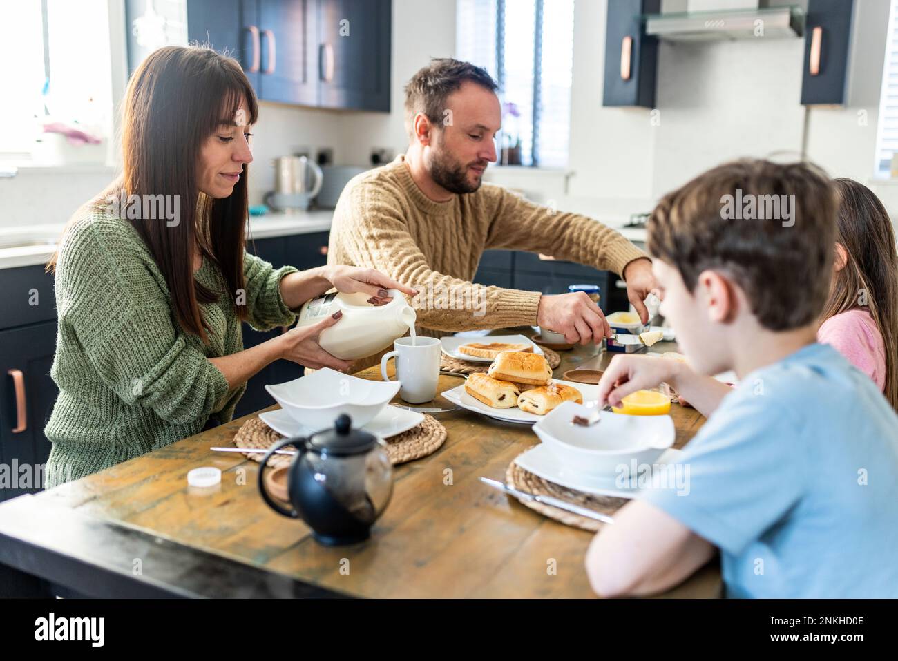 Family having breakfast together in kitchen Stock Photo - Alamy