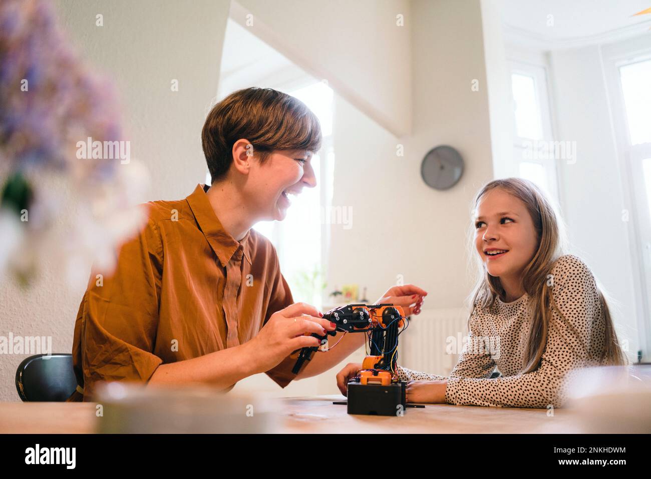 Happy woman with robotic arm looking at daughter in home Stock Photo ...