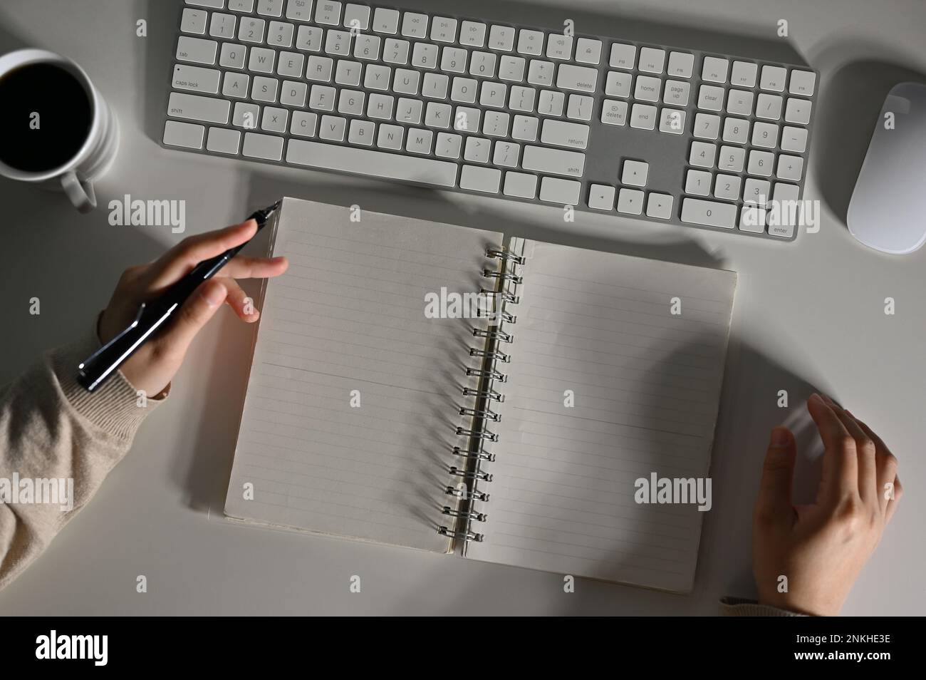Top view of a female working at her desk, doing homework, writing ...