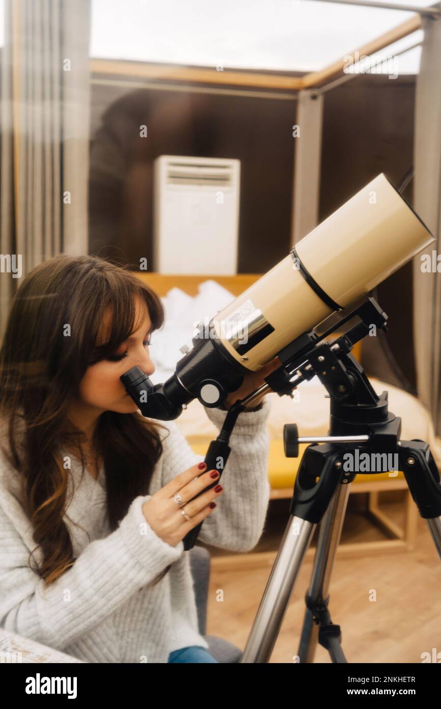 Woman looking through telescope hi-res stock photography and images - Alamy