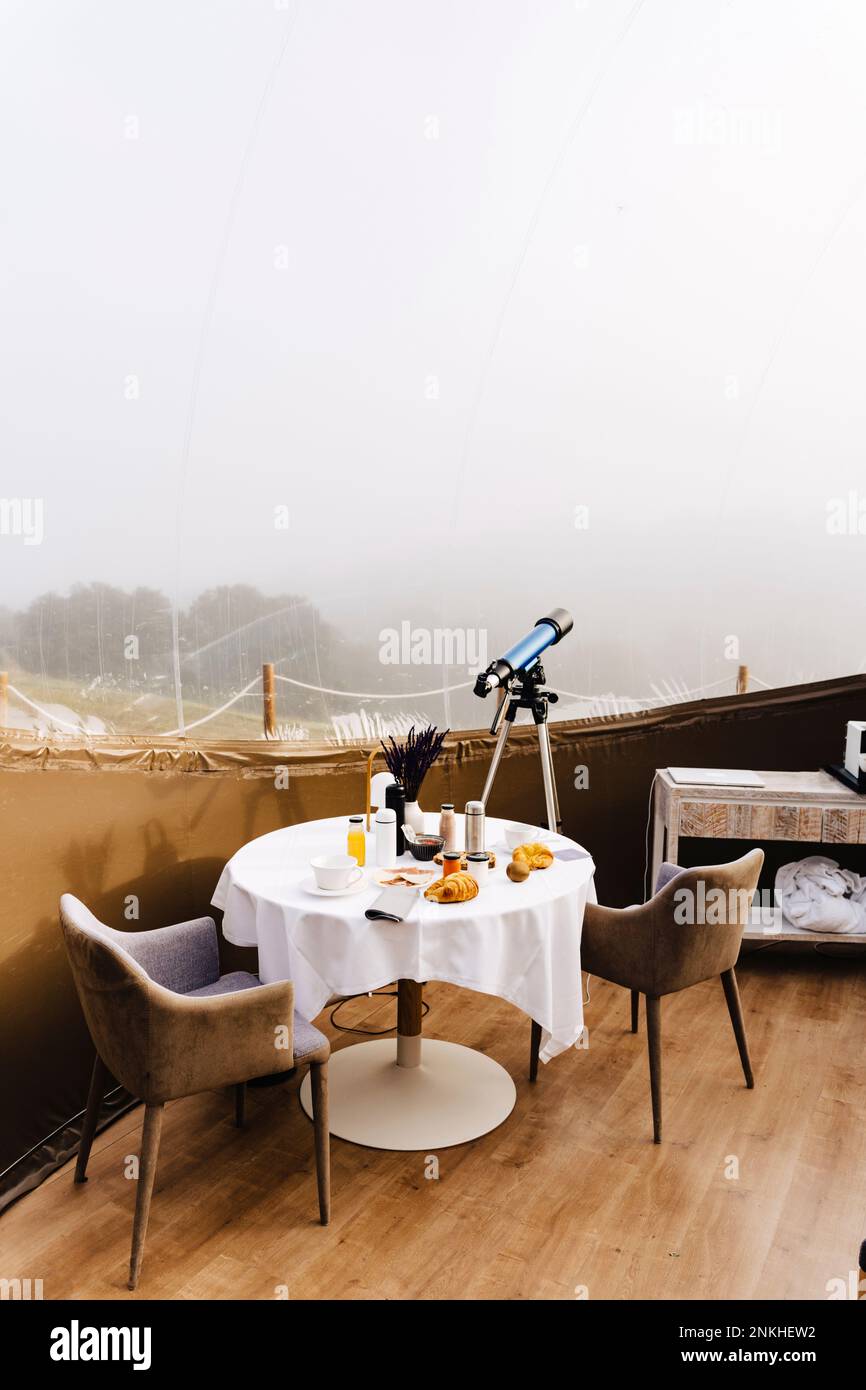 Dining table and telescope in dome tent Stock Photo - Alamy