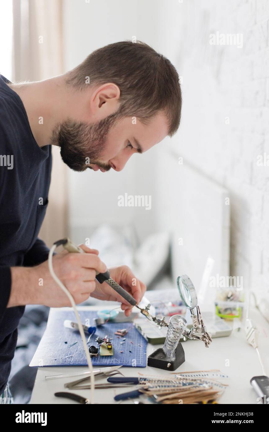 Technician repairing equipment using soldering iron at workshop Stock ...
