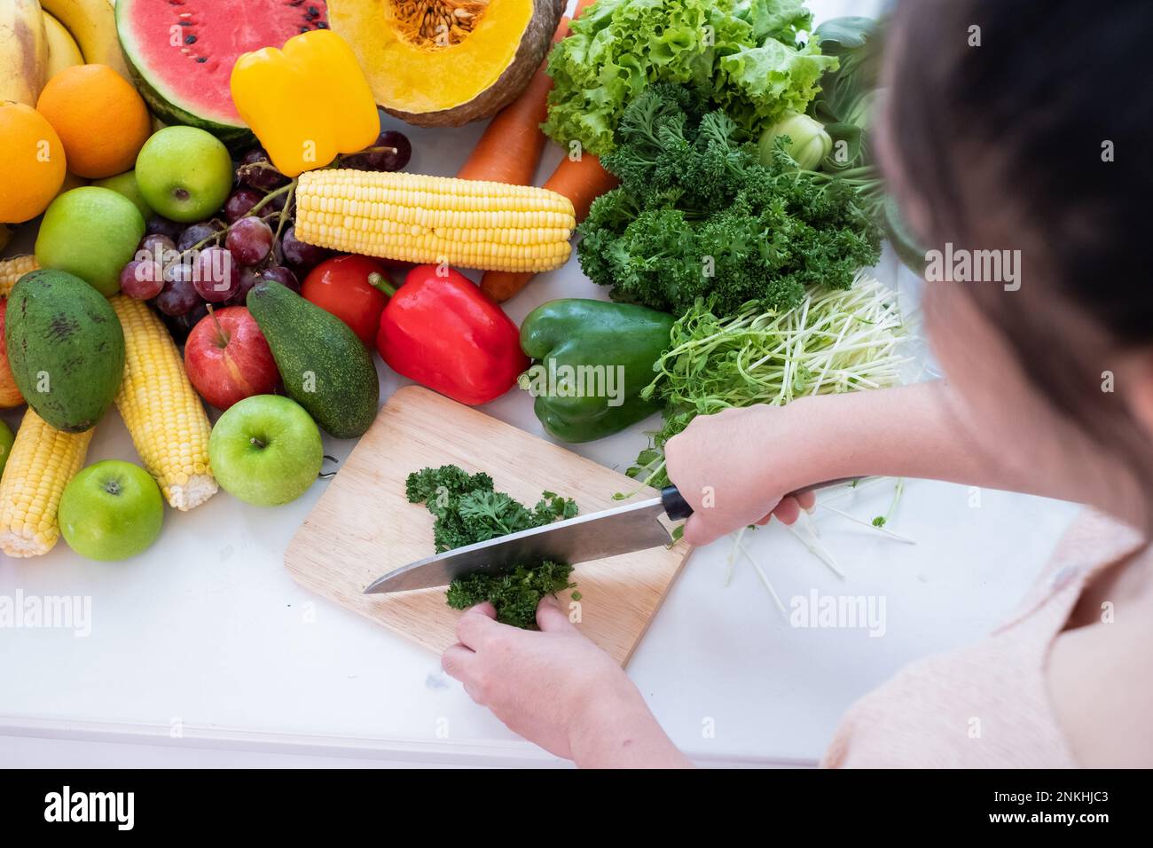 a person's hands are visible holding a knife and chopping vegetables on ...