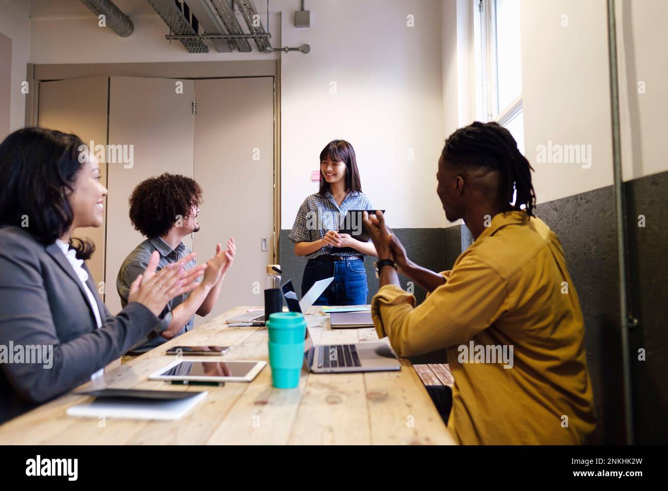 Multiracial colleagues applauding businesswoman at workplace Stock ...