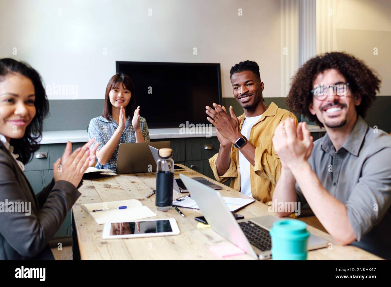 Happy business colleagues applauding in meeting at workplace Stock ...