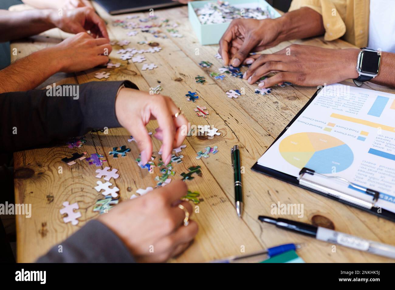 Hands of business colleagues playing jigsaw puzzle at workplace Stock ...
