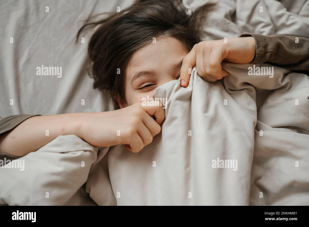 Playful boy covering face with blanket on bed at home Stock Photo - Alamy