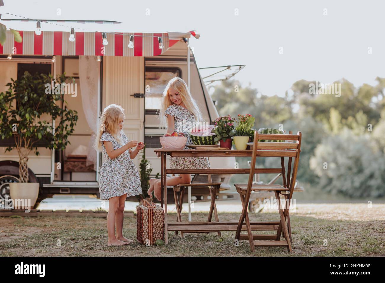 Sisters enjoying picnic in front of camper van Stock Photo - Alamy