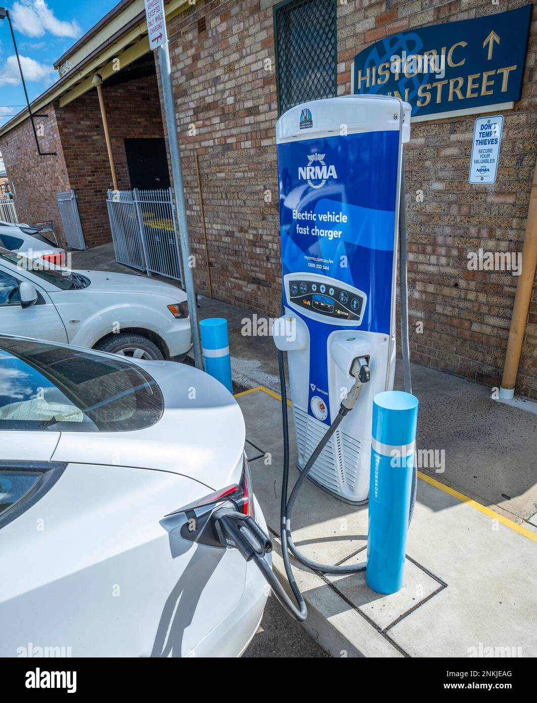 Tesla electric vehicle being recharged at the NRMA EV Charger behind ...