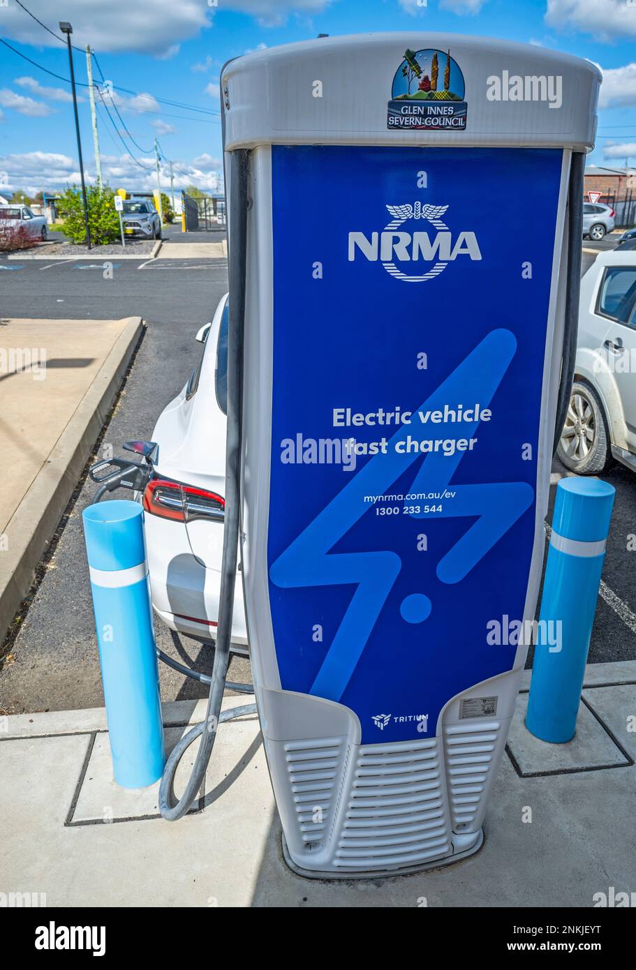 Tesla electric vehicle being recharged at the NRMA EV Charger behind ...