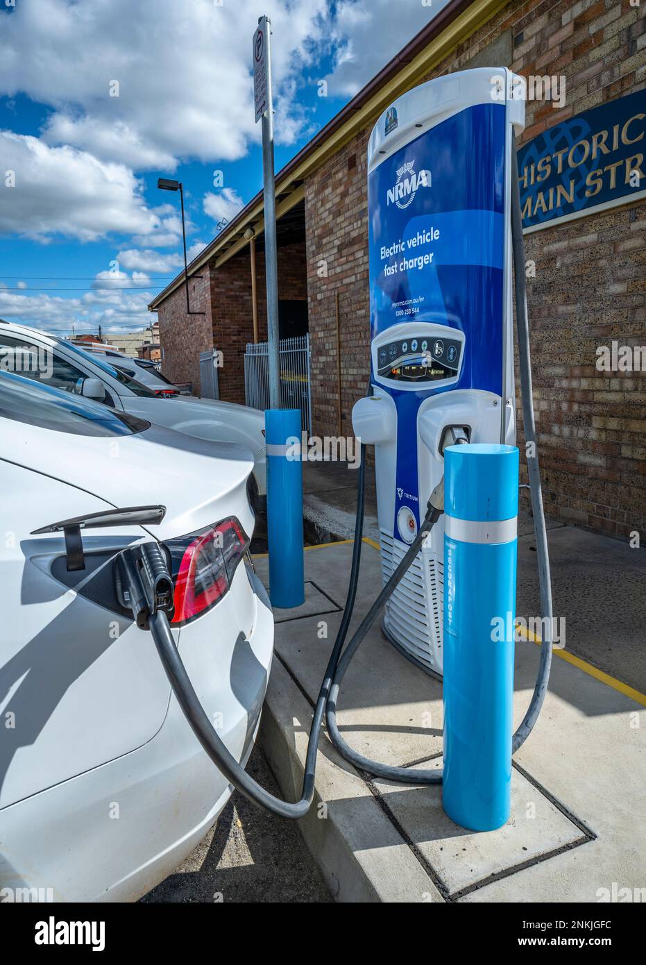 Tesla electric vehicle being recharged at the NRMA EV Charger behind ...