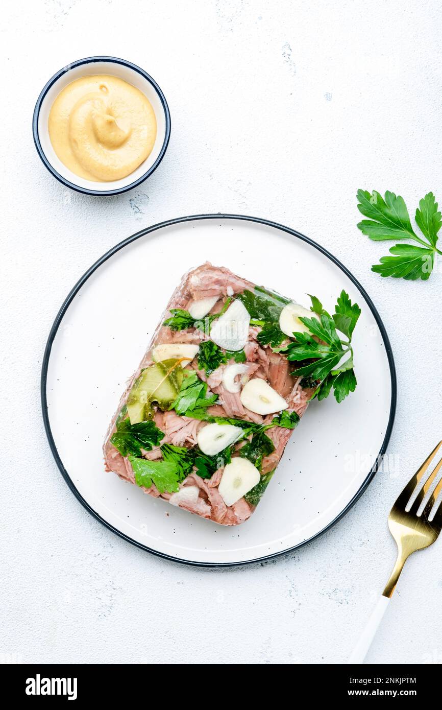 Aspic meat, cold boiled beef in spiced jelly broth on plate, dijon ...