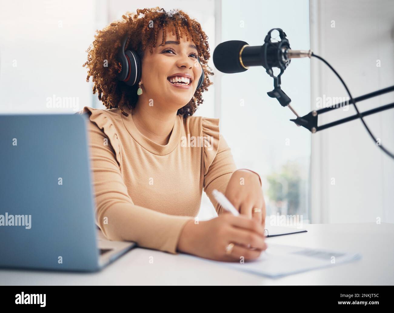 Laptop, microphone and radio with a black woman presenter talking ...