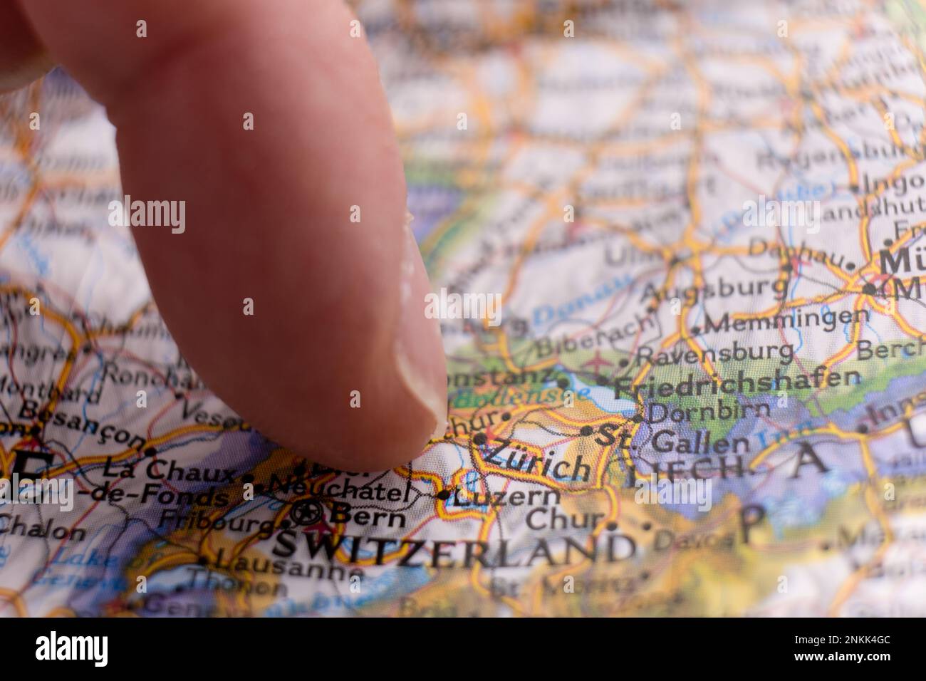 Finger pointing to Zurich Switzerland on detailed colorful map with ...
