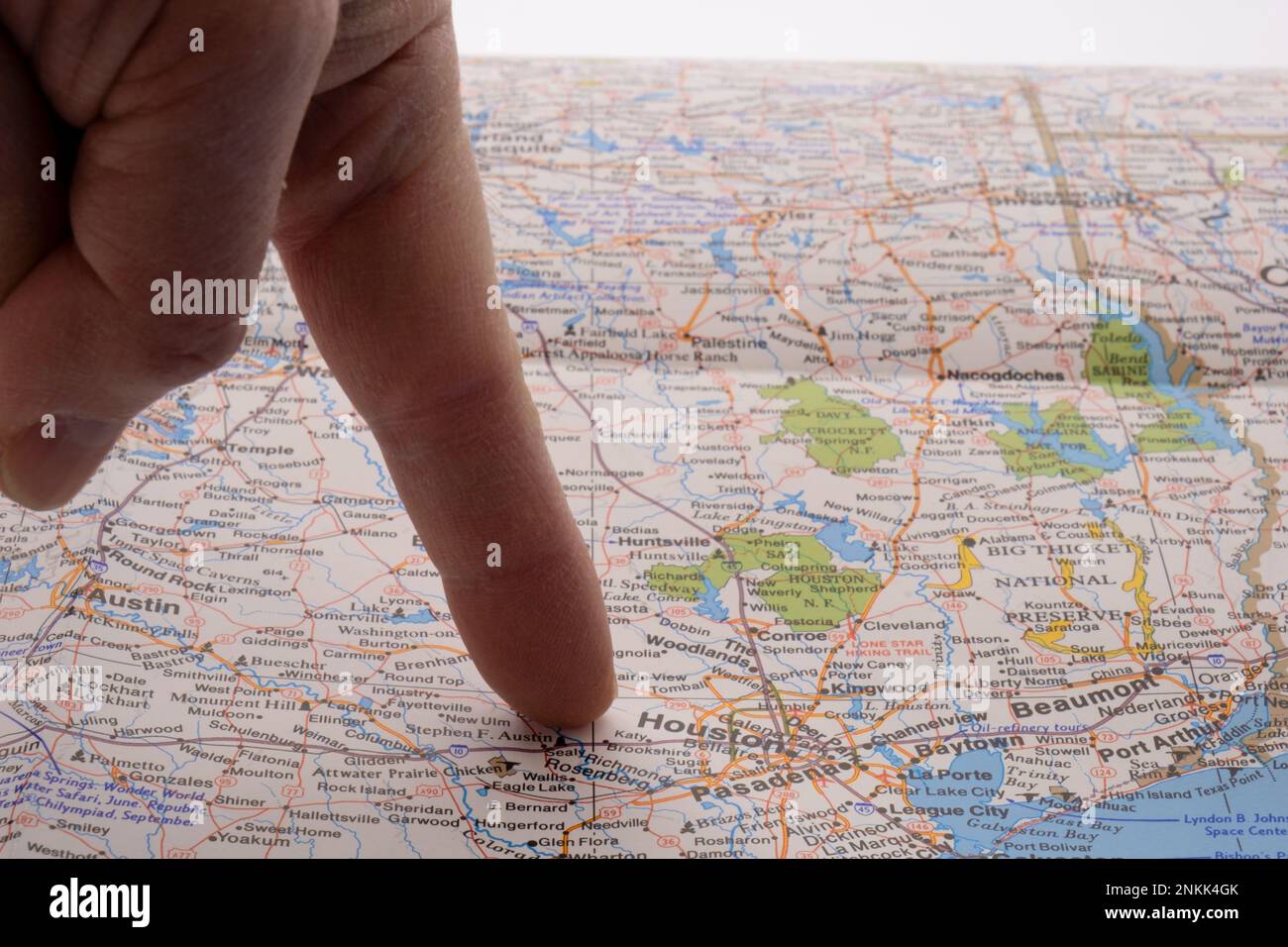 Close up of finger pointing to Houston, Texas on colorful map with ...