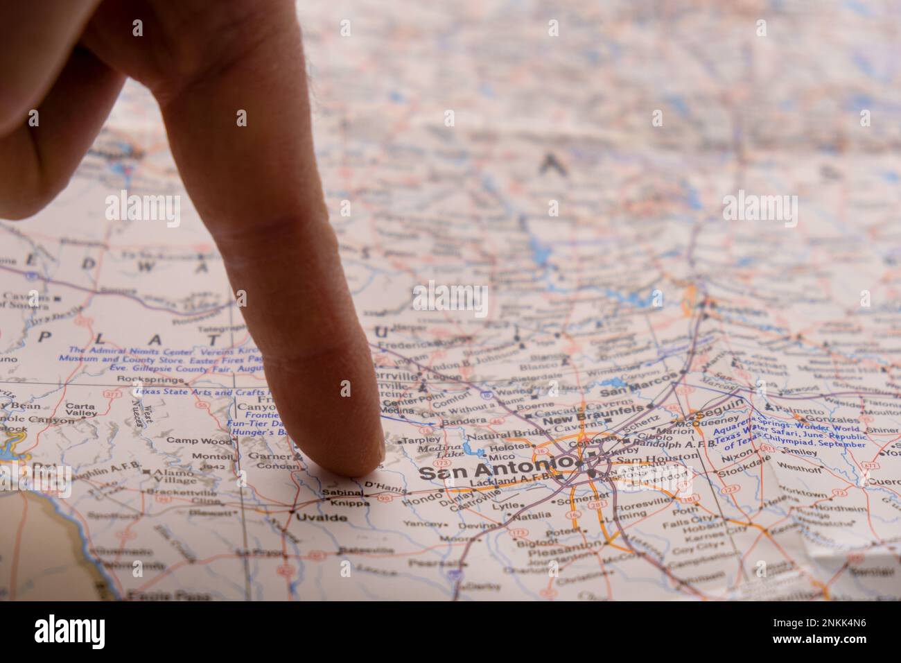 Close up of finger pointing to San Antonio, Texas on detailed colorful ...