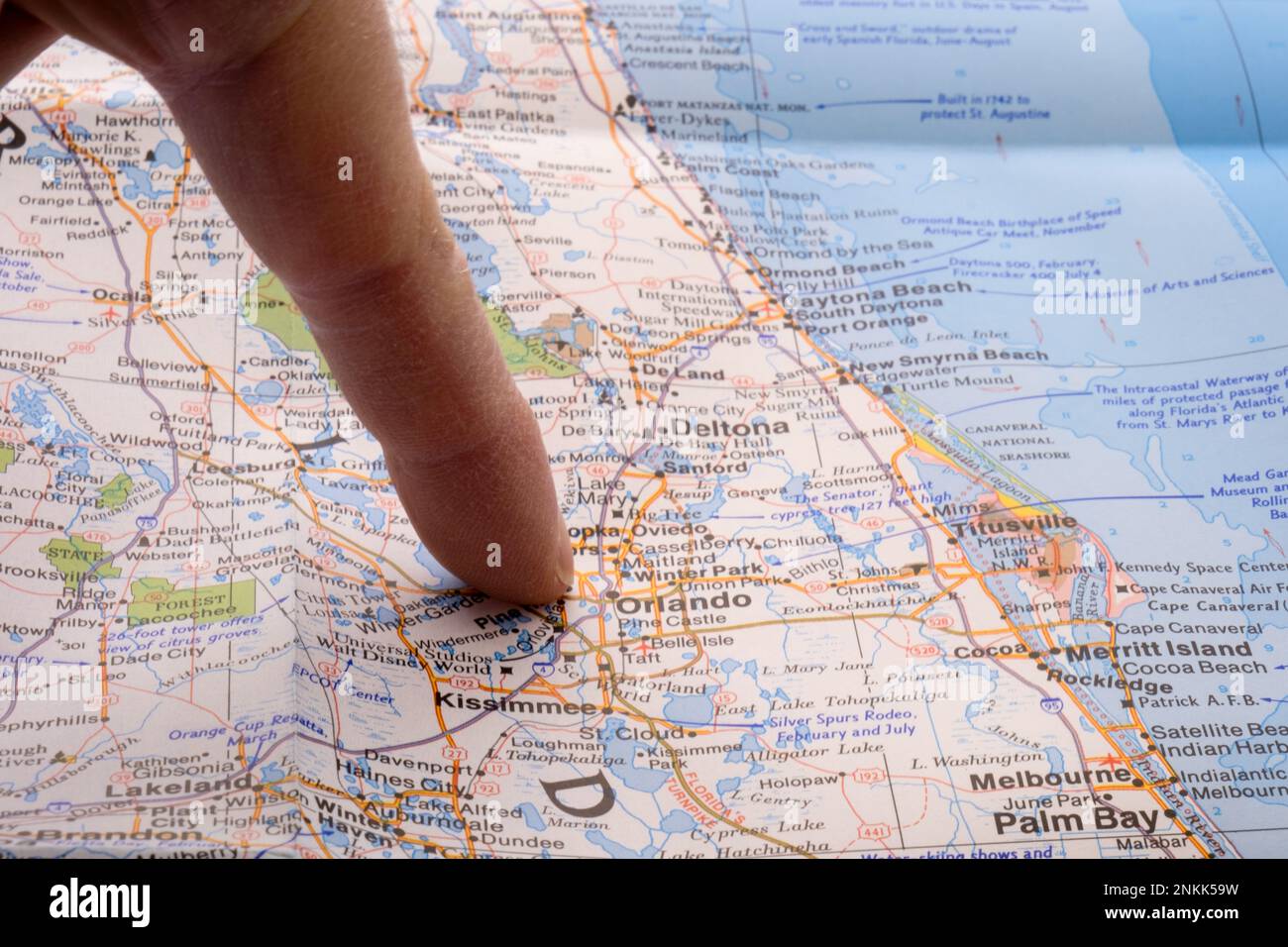 Close up of finger pointing to Orlando, Florida on detailed colorful ...