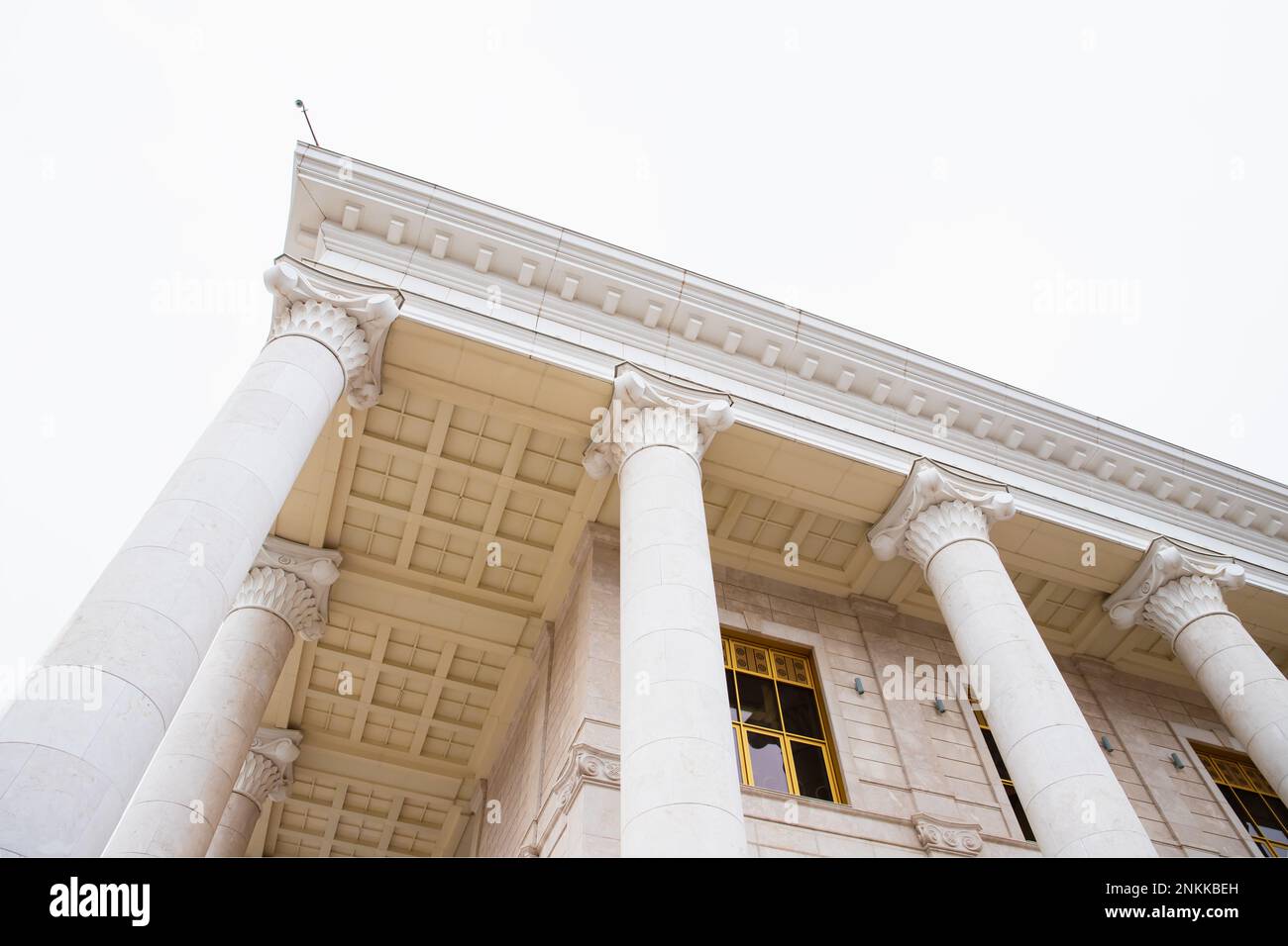 Tall columns on white rain clouds background, entrance to building ...