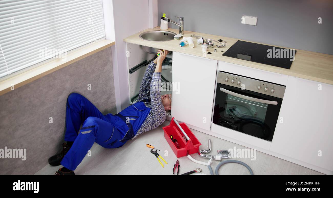 Plumber Cleaning Kitchen Drain And Pipe Using Tools Stock Photo - Alamy