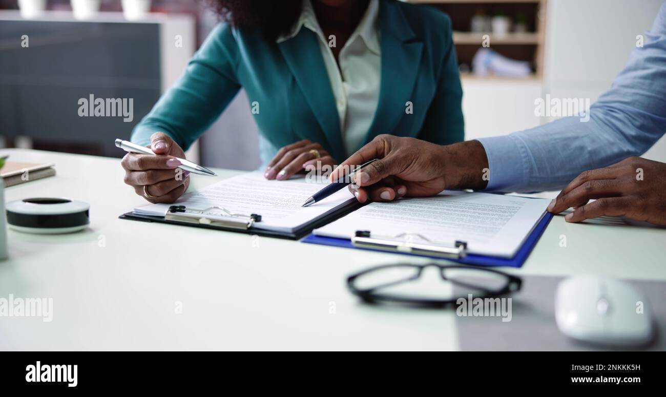 Two Businesspeople Hand Working On Contract Paper Over Desk Stock Photo ...