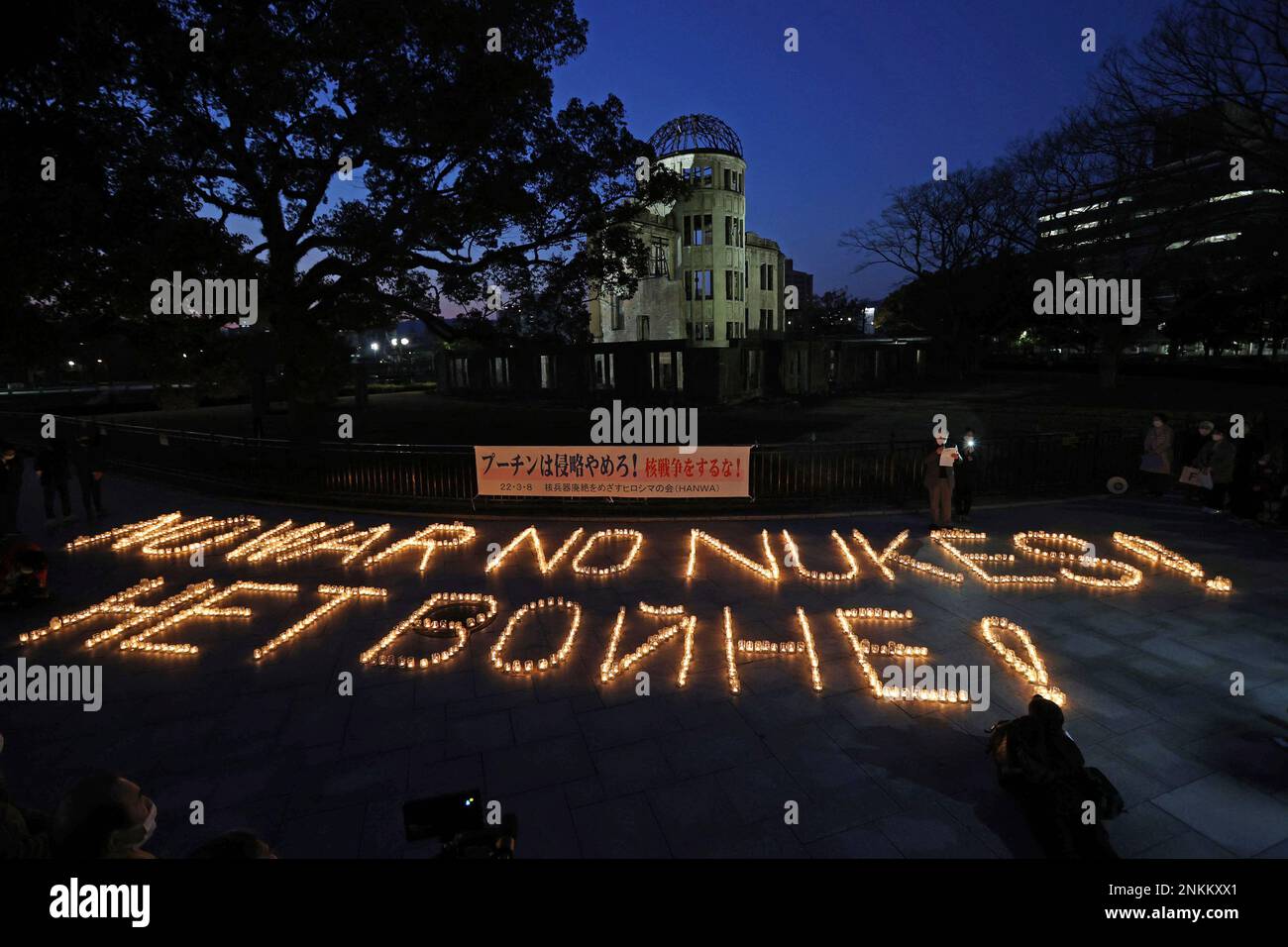 1,300 candles forming a message " No War, No Nukes !" are lit in front ...