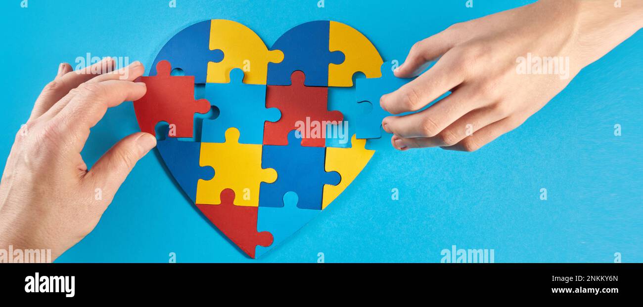 Father and autistic son hands holding jigsaw puzzle heart shape. World ...