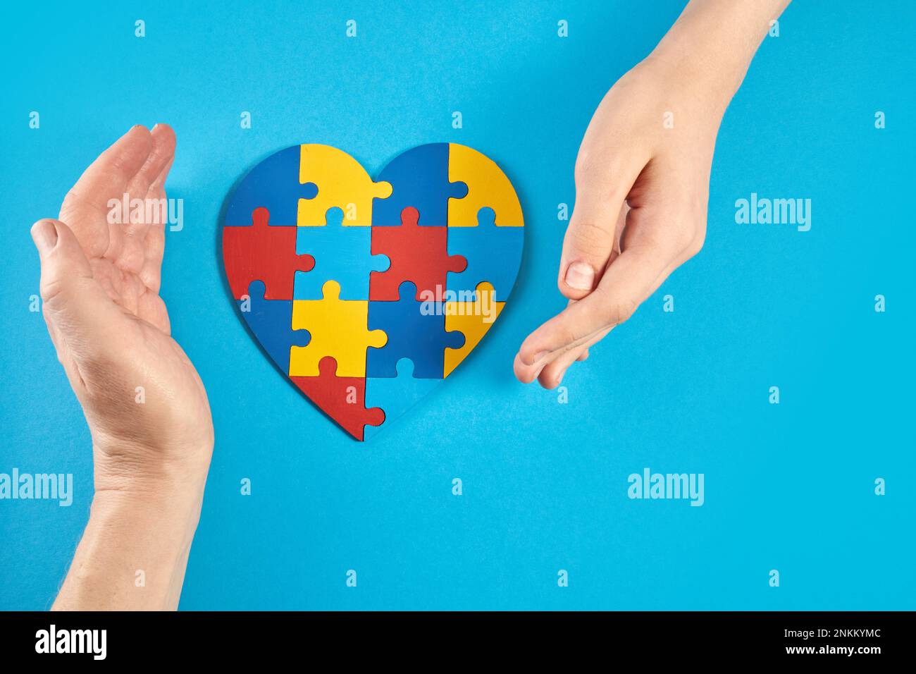 Father and autistic son hands holding jigsaw puzzle heart shape. World ...