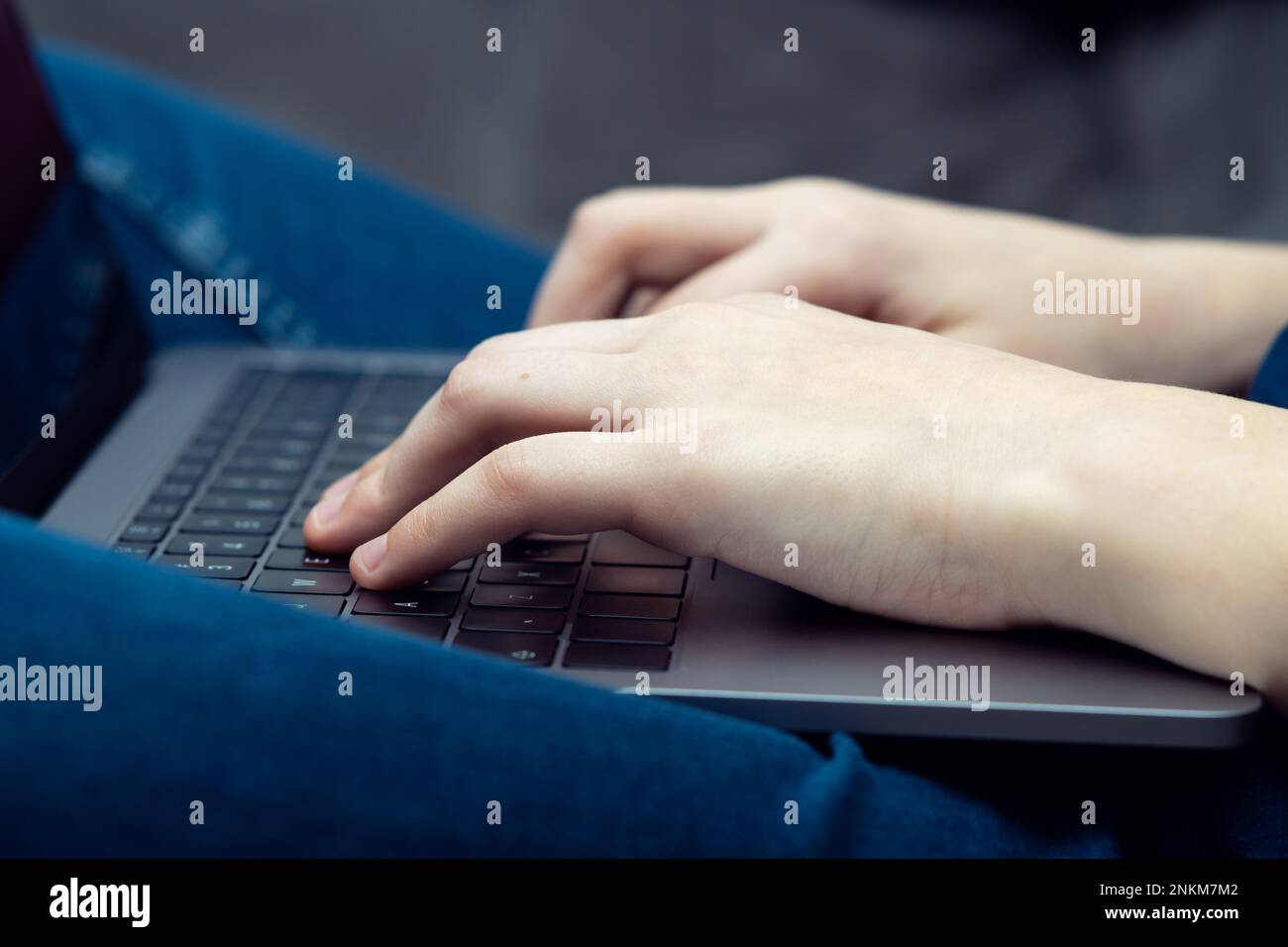 Digital laptop computer on male legs, side view closeup. Young business ...