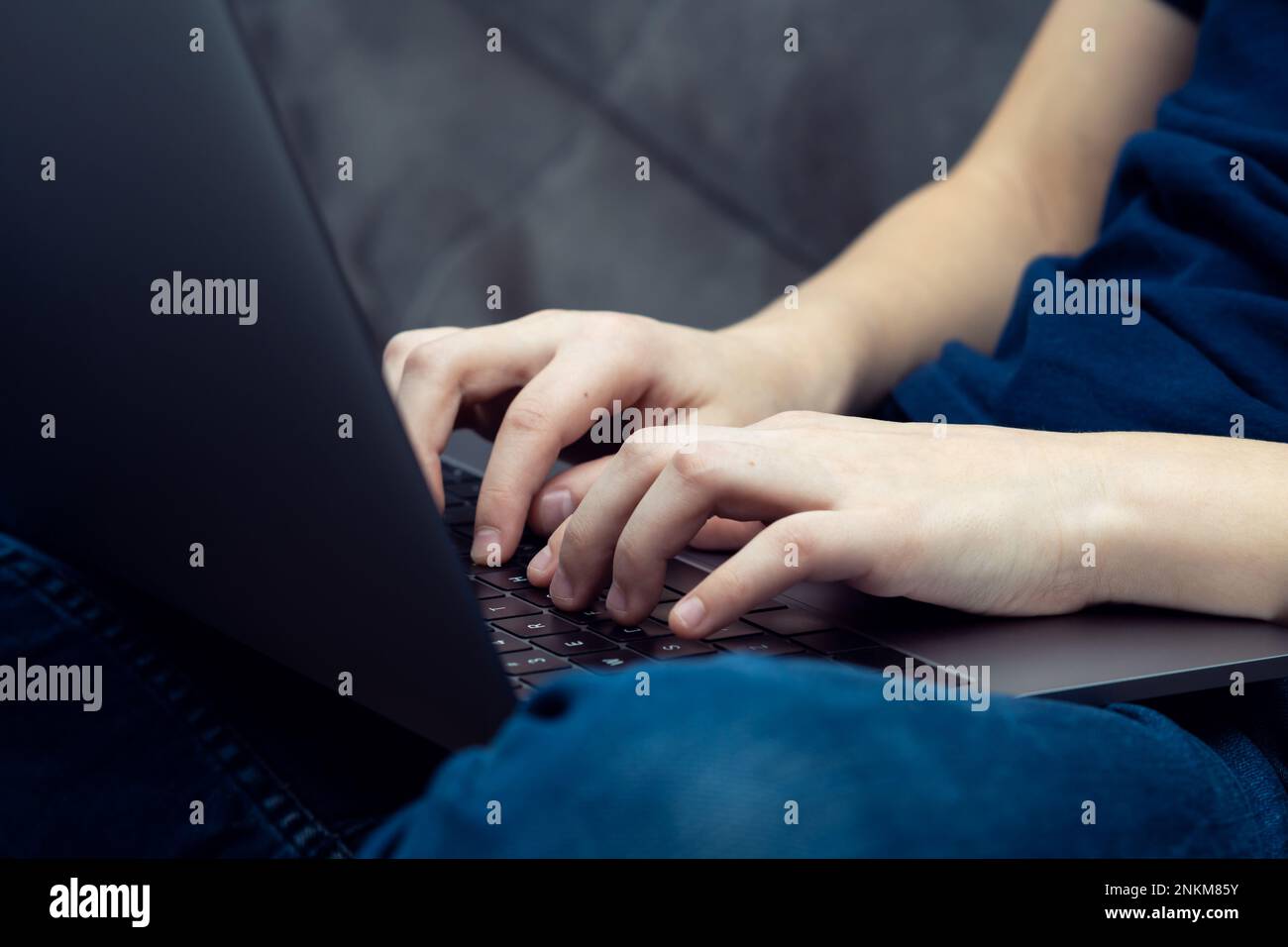 Digital laptop computer on male legs closeup. Young business man typing ...