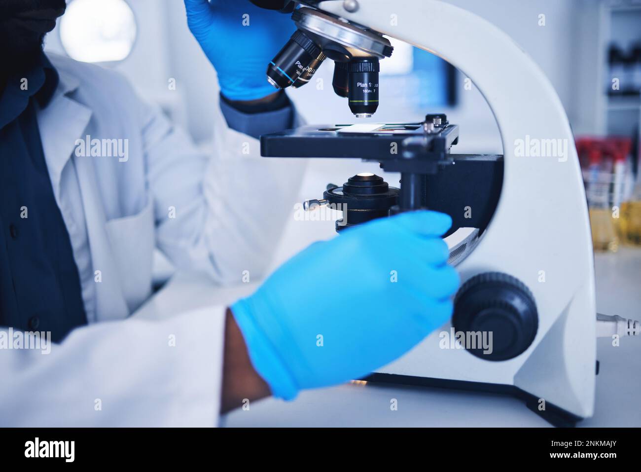 Science, microscope and hands of a scientist in a lab doing research ...