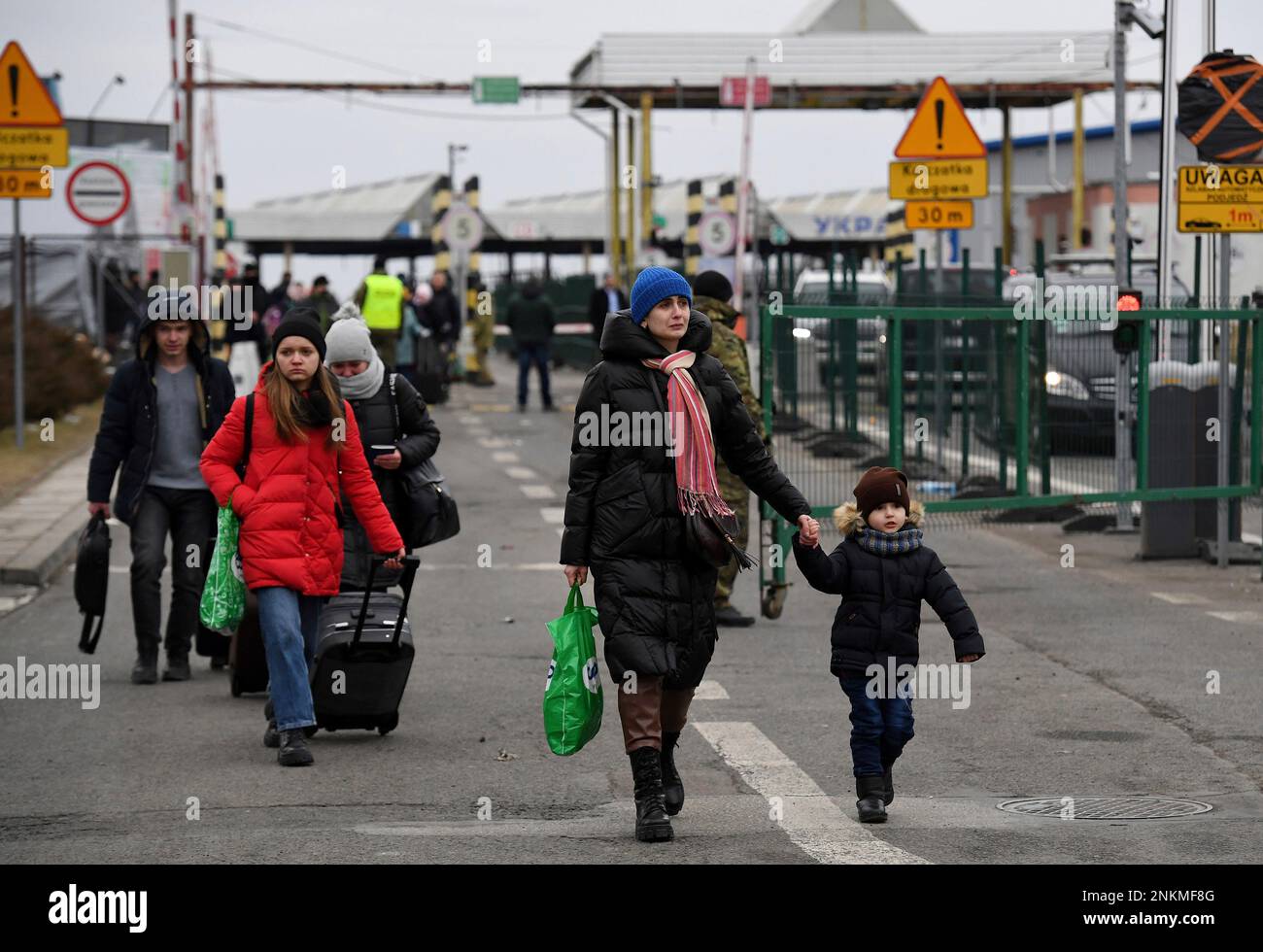 A woman holds the hand of a child as she arrives at the Ukrainian ...