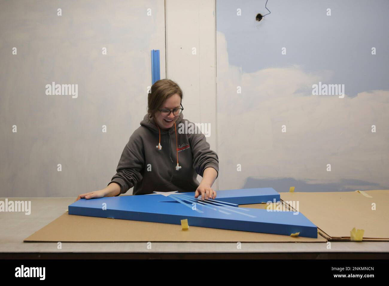 Vinyl specialist Karen Havey applies a vinyl sticker to a large letter ...