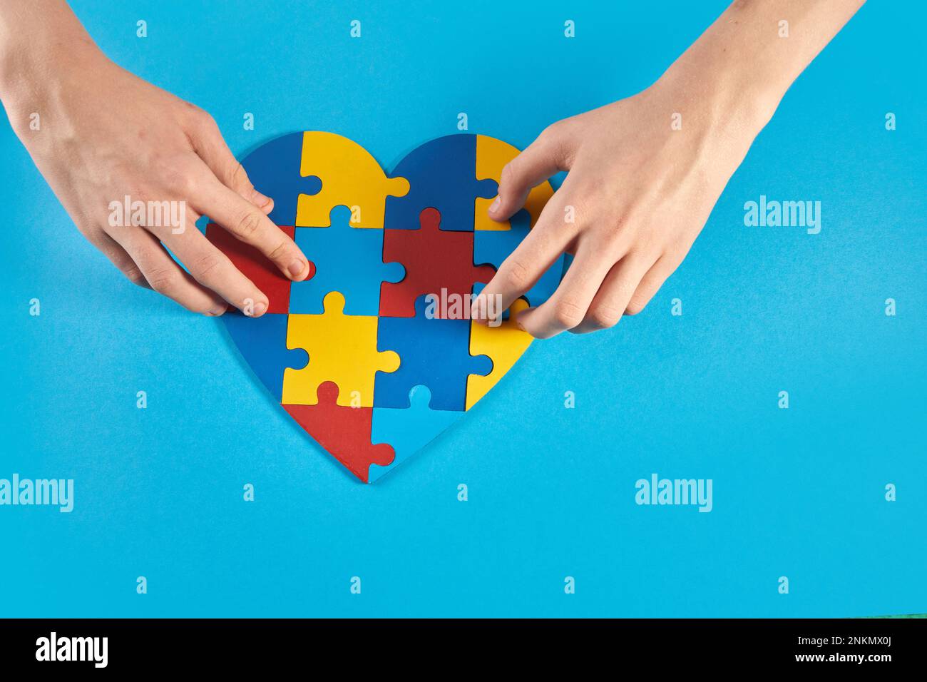 Autistic boy hands holding jigsaw puzzle heart shape. World Autism ...