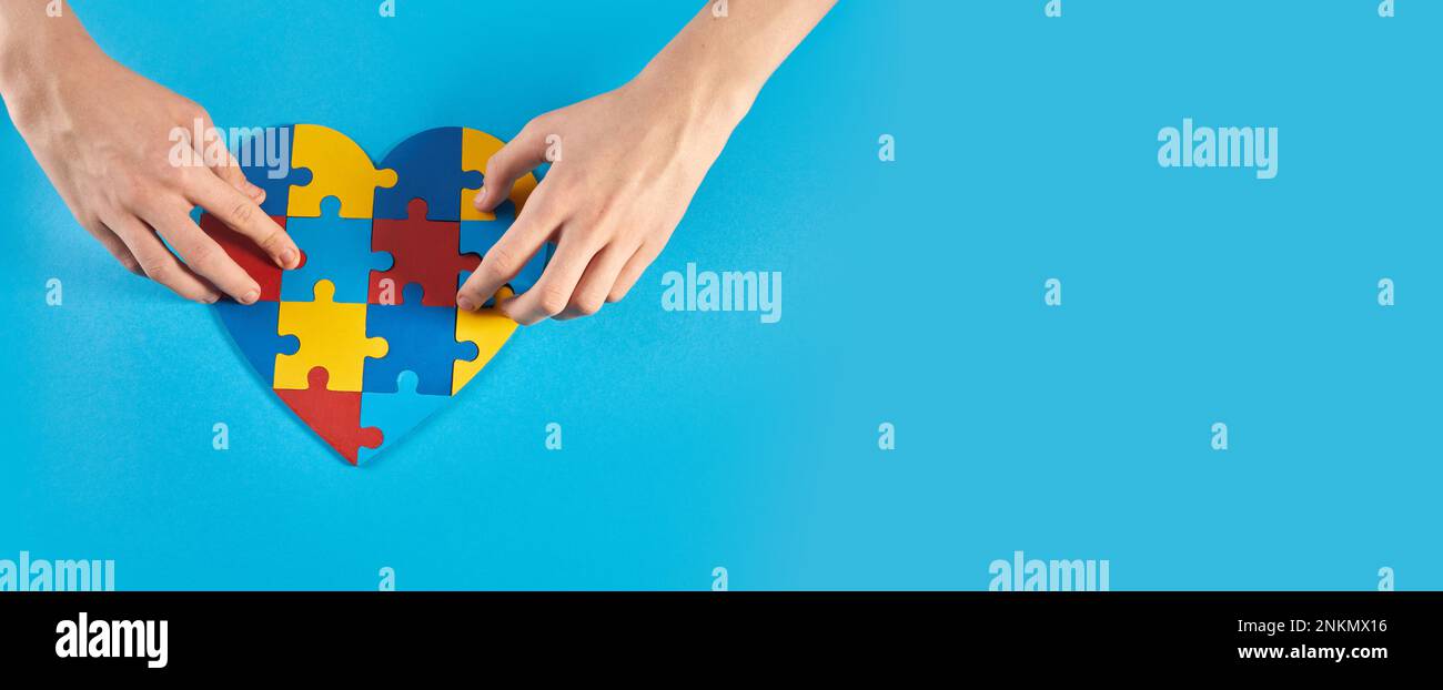 Autistic boy hands holding jigsaw puzzle heart shape. World Autism ...