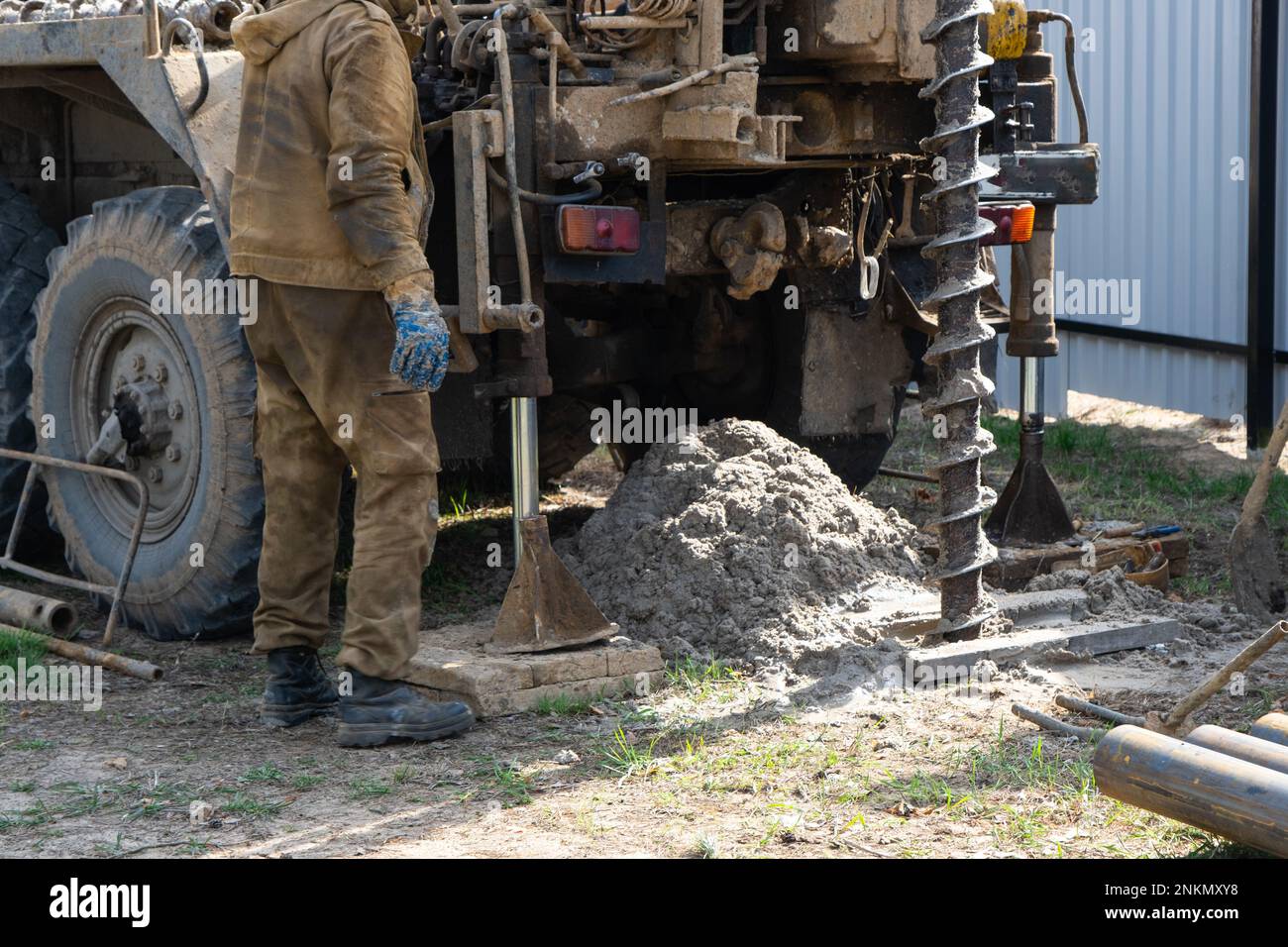Team of workers with drilling rig on car are drilling artesian well for ...