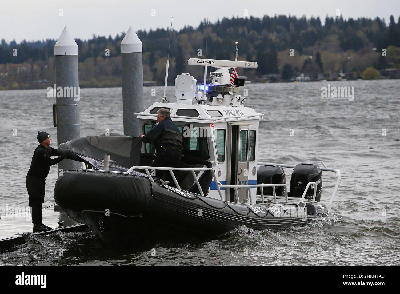 A Seattle Police boat returns a run away kite to Andrew Mesher as he ...