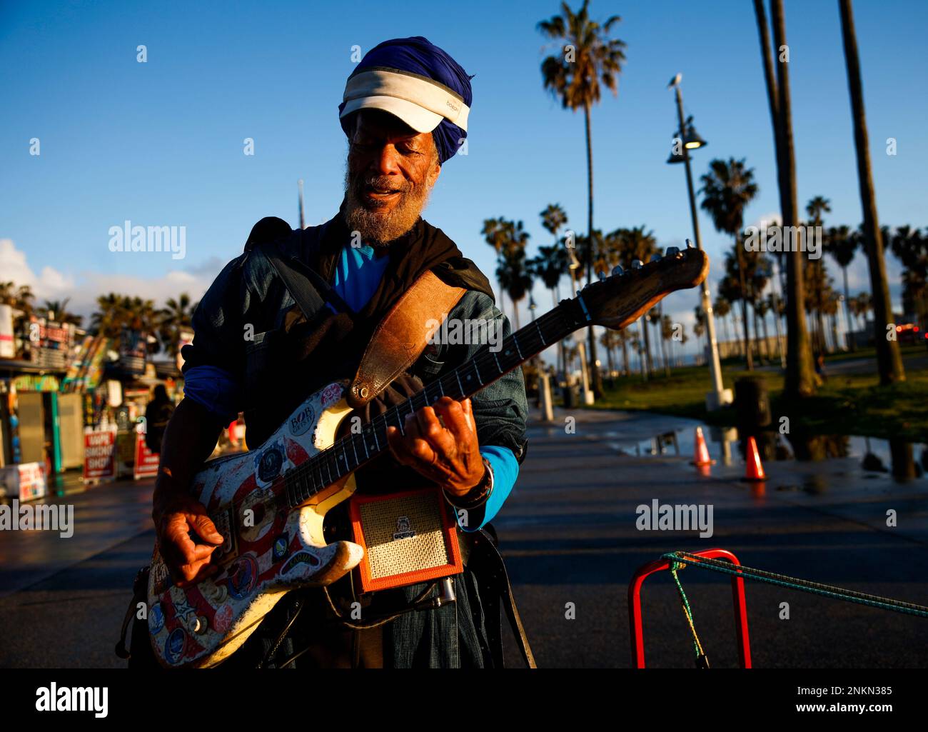 Harry Perry plays guitar along the Venice Beach boardwalk during the ...
