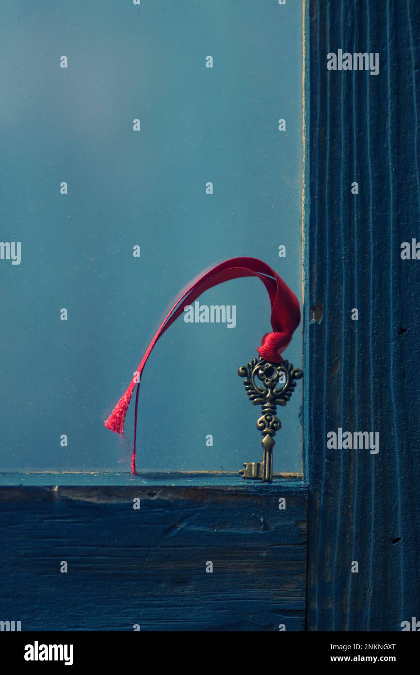 Small key with red ribbon in the window Stock Photo - Alamy