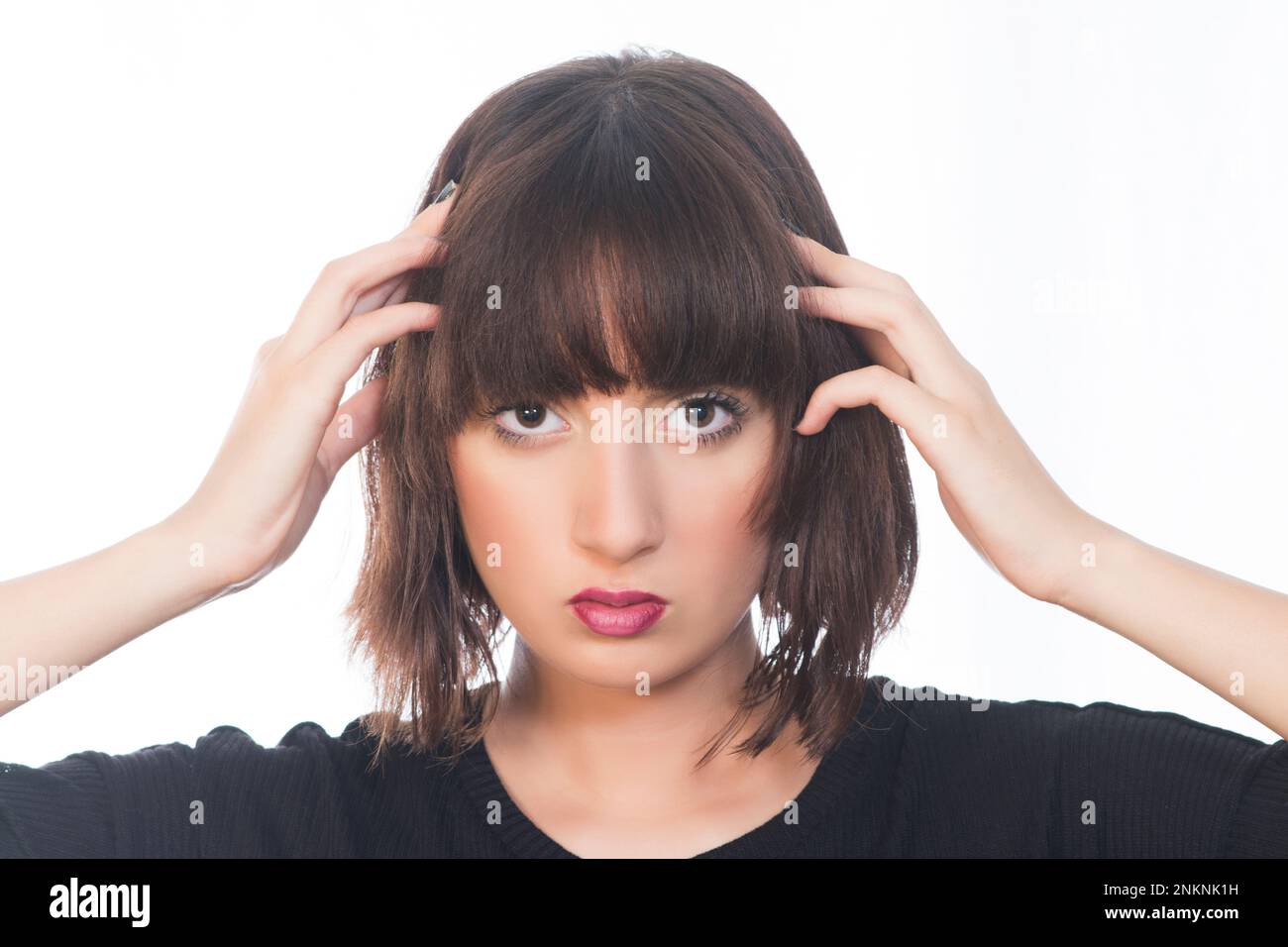 Serious woman head in hands looking at camera Stock Photo - Alamy
