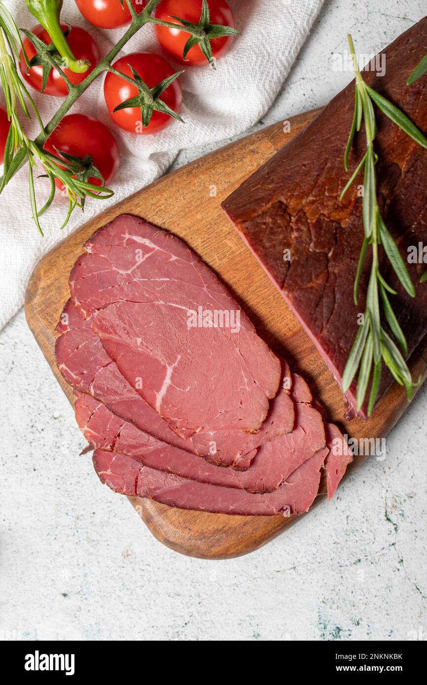 Dry meat. Slices of dried and smoked dry meat on a wooden board. Beef ...