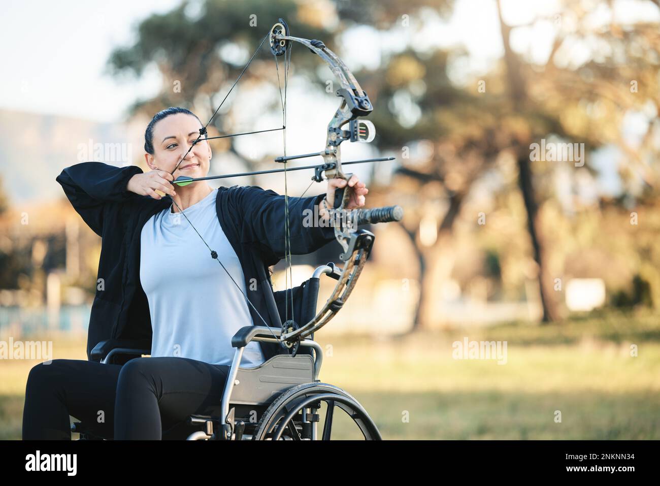 Disabled sports woman, outdoor archery in wheelchair and challenge with ...