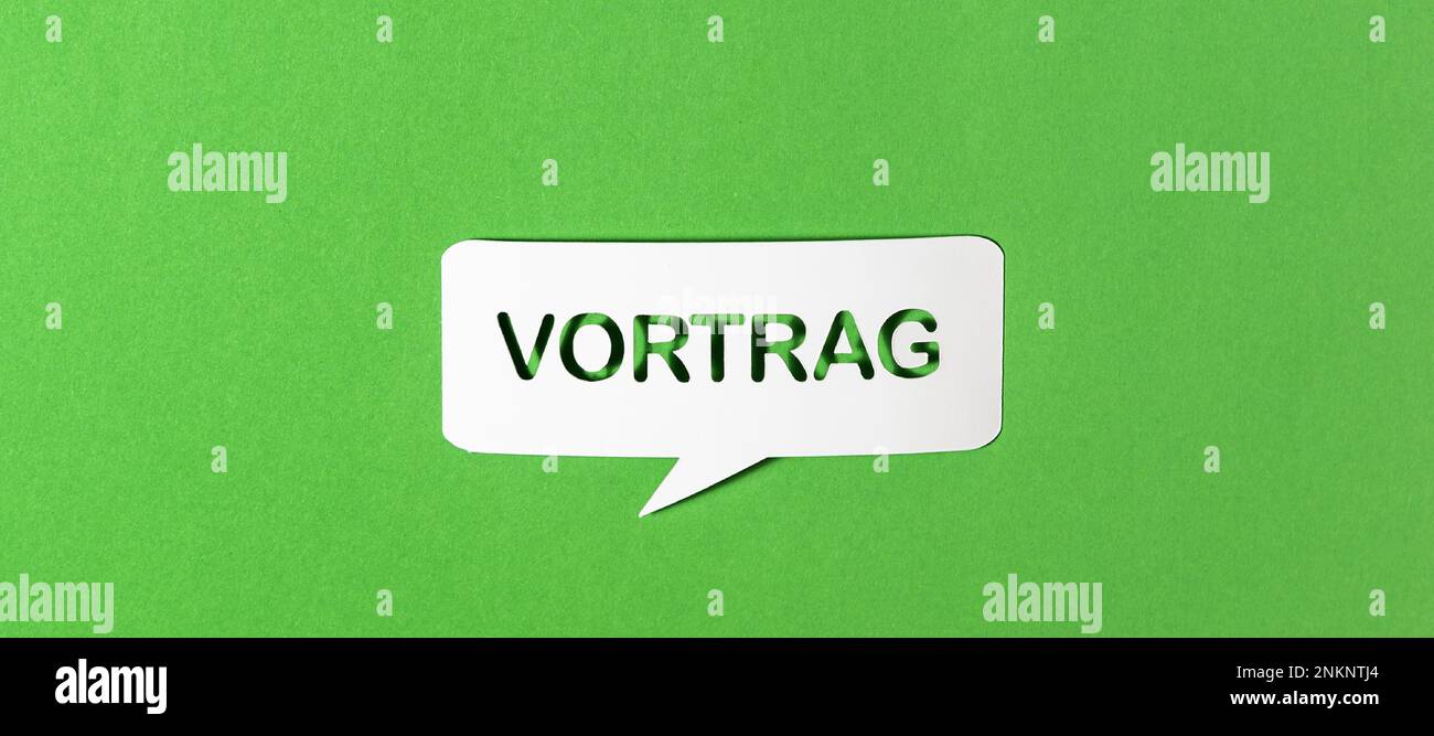 German text lecture in a paper speech bubble punched out on green paper ...