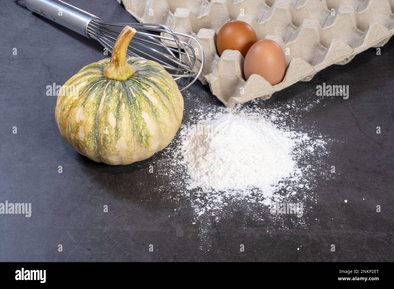 Pumpkin fruit, eggs and all-purpose flour powder for bakery on a dark ...