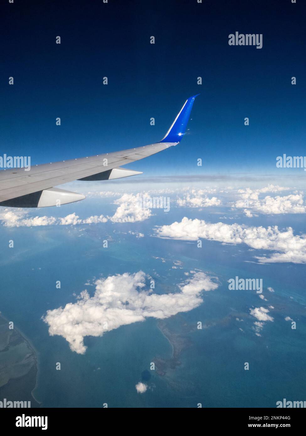 The wing of an aircraft flying over the coastline of Costa Rica in ...