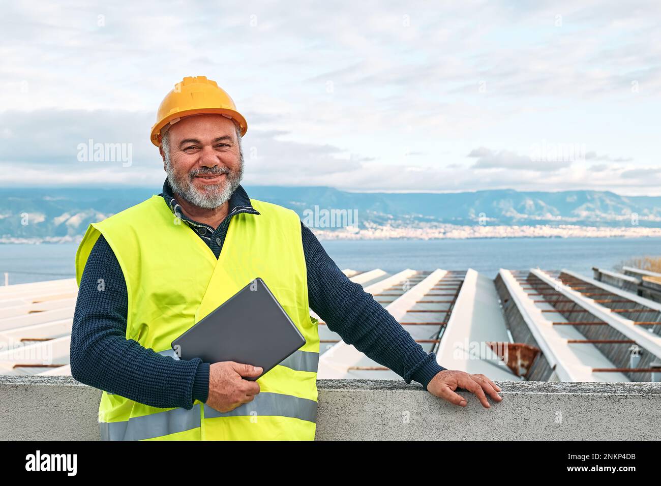 Portrait of smiling middle aged bearded supervisor in hardhat and ...