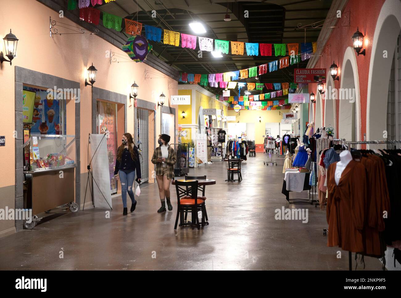 People walk through El Mercado, a shopping and dining area inside the ...
