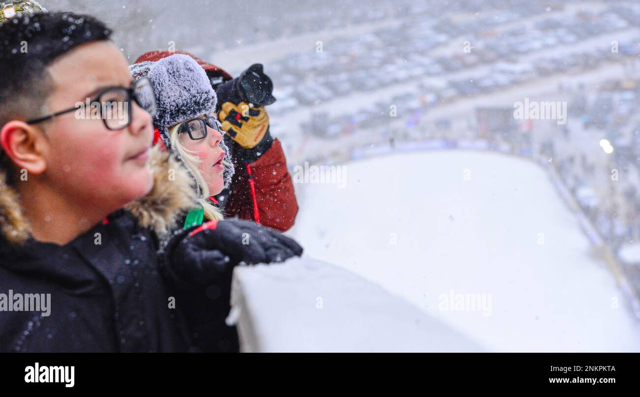 Children watch as ski jumpers go off the inrun during the Pepsi ...